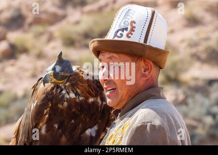 Kyrgyz hunter or Berkutchi hugging a golden eagle, Kyrgyzstan Stock ...