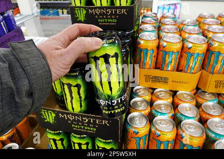 A display of Monster energy drinks cans on the shelves of a grocery ...