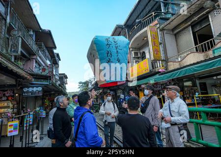 Shifen, Taiwan - February 17, 2023: People lighting lanterns in the ...