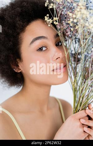 Pretty African-American woman holding big snowflake on light blue ...