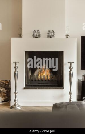 Modern vases with decor on fireplace in room Stock Photo - Alamy