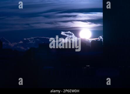Sun setting behind apartment buildings Stock Photo - Alamy