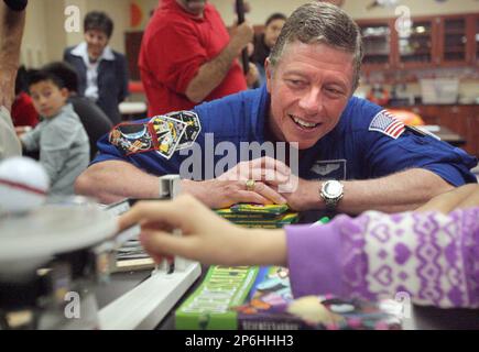 American astronaut Michael Edward Fossum looks up at the tree he helped ...