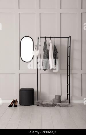 Simple hallway interior with clothing rack, mirror and empty wall ...