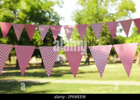 Pink bunting flags in park. Party decor Stock Photo - Alamy