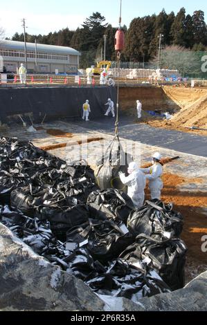 Workers bring soil contamination with radioactive substances into a ...