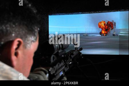 A weapons officers fires a machine gun during a live fire drill aboard ...