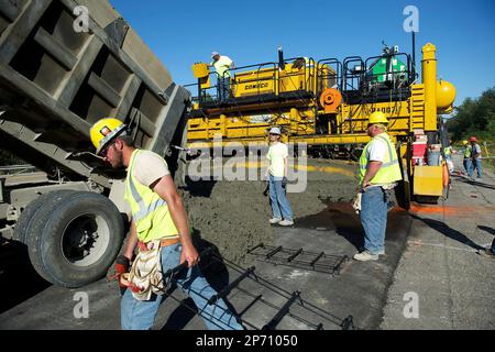 Feet of construction workers paving a road Stock Photo - Alamy