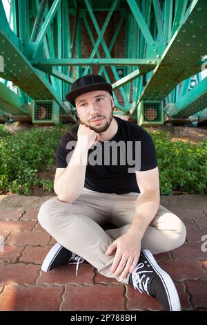 Thoughtful smiling guy relaxing on couch, looking away and smiling ...