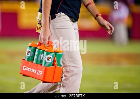 A detail of a trainer holding Gatorade bottles while the University of ...