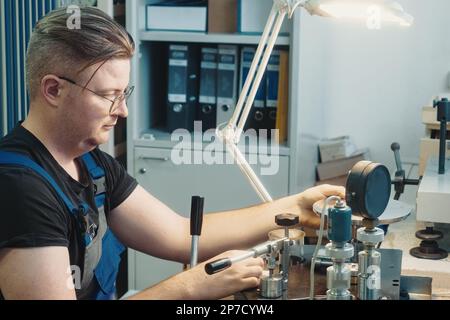 Professional calibration of pressure gauges and sensors. Working man is ...