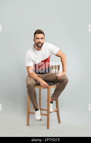 Handsome man posing against grey background Stock Photo - Alamy