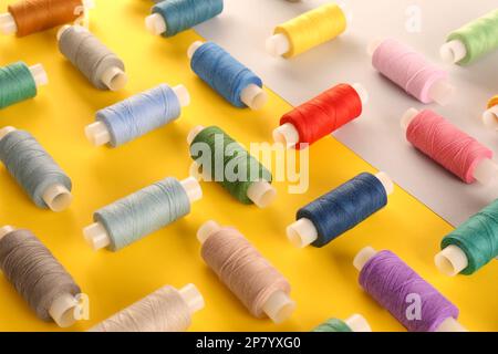 Different sewing threads on color background Stock Photo - Alamy