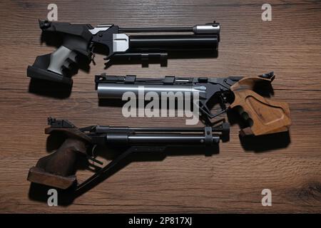 Different pistols on wooden table. Gun shooting sport Stock Photo - Alamy