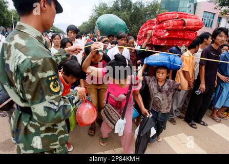 A Chinese paramilitary police lifts a security line to allow a Myanmar ...
