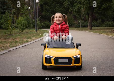 Cute little girl driving children's car outdoors Stock Photo - Alamy