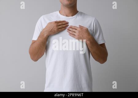 Man holding hands near chest with illustration of lungs on green ...