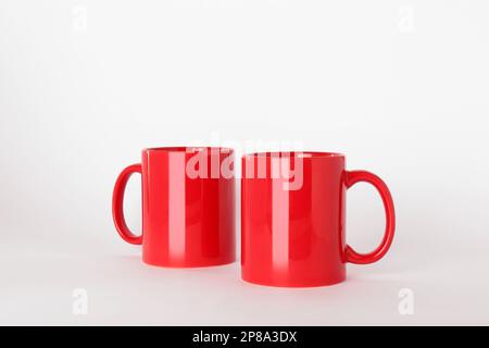Blank red ceramic mugs on light blue background Stock Photo - Alamy