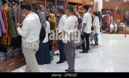 many people are shopping in batik clothes shop. Batik is Indonesian ...