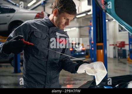 Male conducts full technical inspection of car Stock Photo - Alamy
