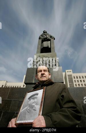 A member of the Belarusian Communist party holding a portraits of Josef ...