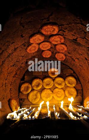 Obi-non bread being baked in a small bakery in the old city of Bukhara ...