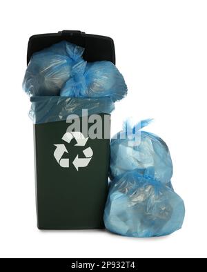 Dark green recycling bin overfilled with garbage bags on white ...