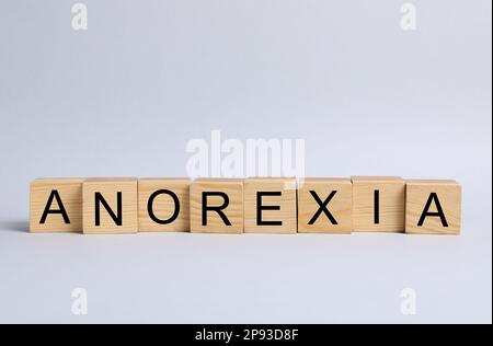 Word Anorexia made of wooden letters on light blue background, flat lay ...