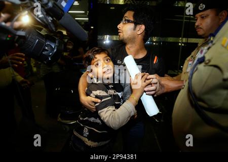 Azharuddin Mohammed Ismail, 10, center, stretches as his mother Shamim ...