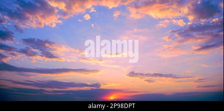Fantastic pink sunset against bright blue sky with fluffy white clouds ...