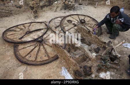 An archaeologist works around a 1,800-year-old bronze chariot at an ...
