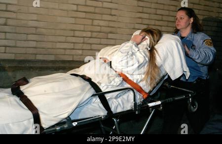Christina Korbe covers her face as she is taken from the Allegheny ...