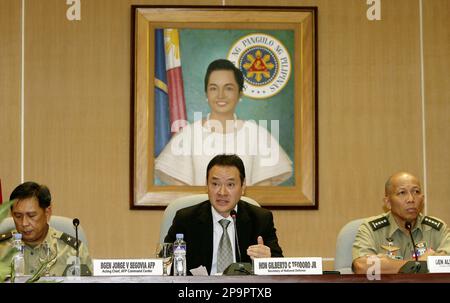 Philippine Defense Secretary Gilberto Teodoro, left, clenches the hand ...