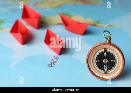 Bright paper boats and compass on world map, flat lay Stock Photo - Alamy