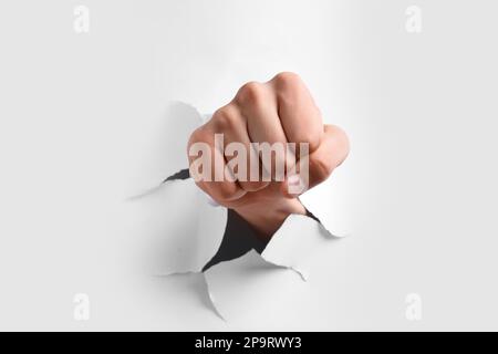 Man breaking through white paper with money in fist, closeup Stock ...
