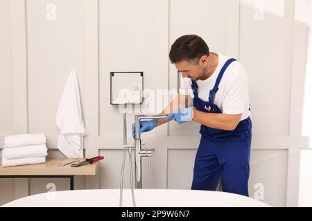 Professional plumber installing water tap in bathroom Stock Photo - Alamy
