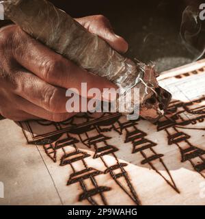 An artist using a pyrography tool to create a pyrogravure. Wood burning ...