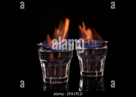 Flaming vodka in shot glasses on black background Stock Photo - Alamy