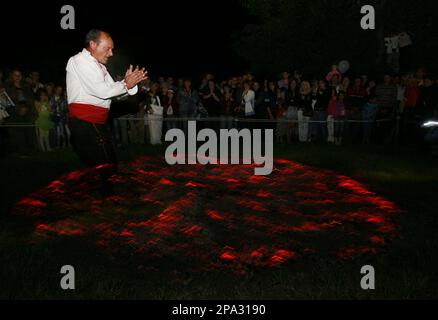 Bulgarian Nestinari dancer performs barefoot over smoldering embers as ...