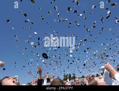 U.S. Naval Academy midshipmen toss their covers in the air during ...