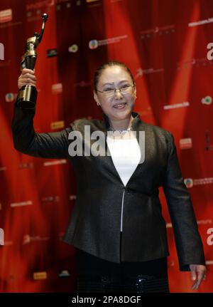 Chinese actress Si Qin Gao Wa and Chinese actor Jet Li hold trophies ...