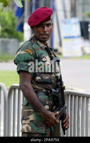 A Sri Lankan army commando stands guard as soldiers march past during ...