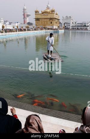 A Sikh cleans the Sarovar (water tank) – around the Golden Temple (Sri ...
