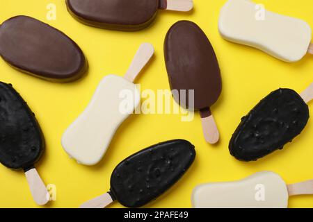 Different glazed ice cream bars on yellow background, flat lay Stock ...