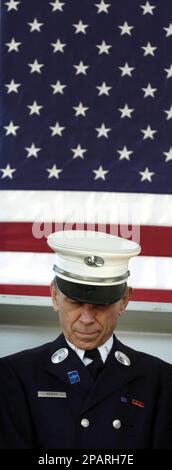A New York City firefighter pauses next to flowers left at the World ...