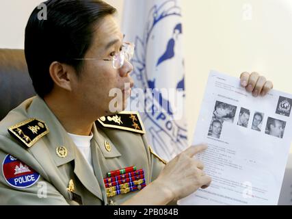 Keo Vannthan, Director of Cambodia's Interpol bureau, shows pictures ...