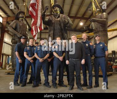 The three bronze sculpture “To Lift A Nation” sits in a warehouse on ...