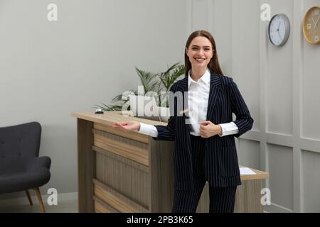 Portrait of beautiful receptionist near counter in hotel Stock Photo ...