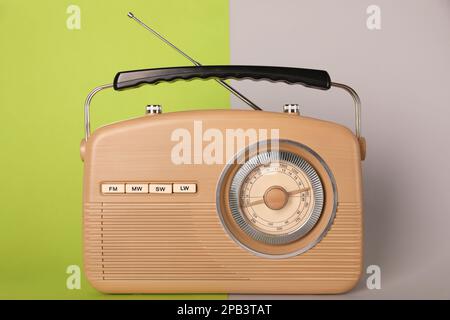 Portable retro radio receiver on orange background. Space for text ...
