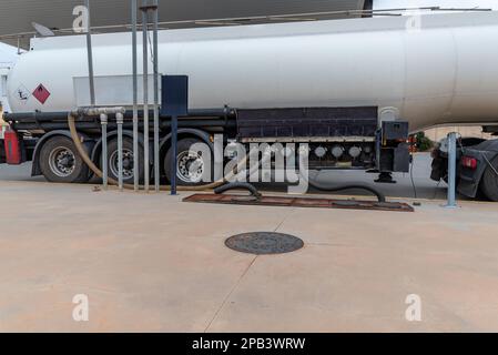 Fuel tanker truck unloading at a service station, unloading with two ...